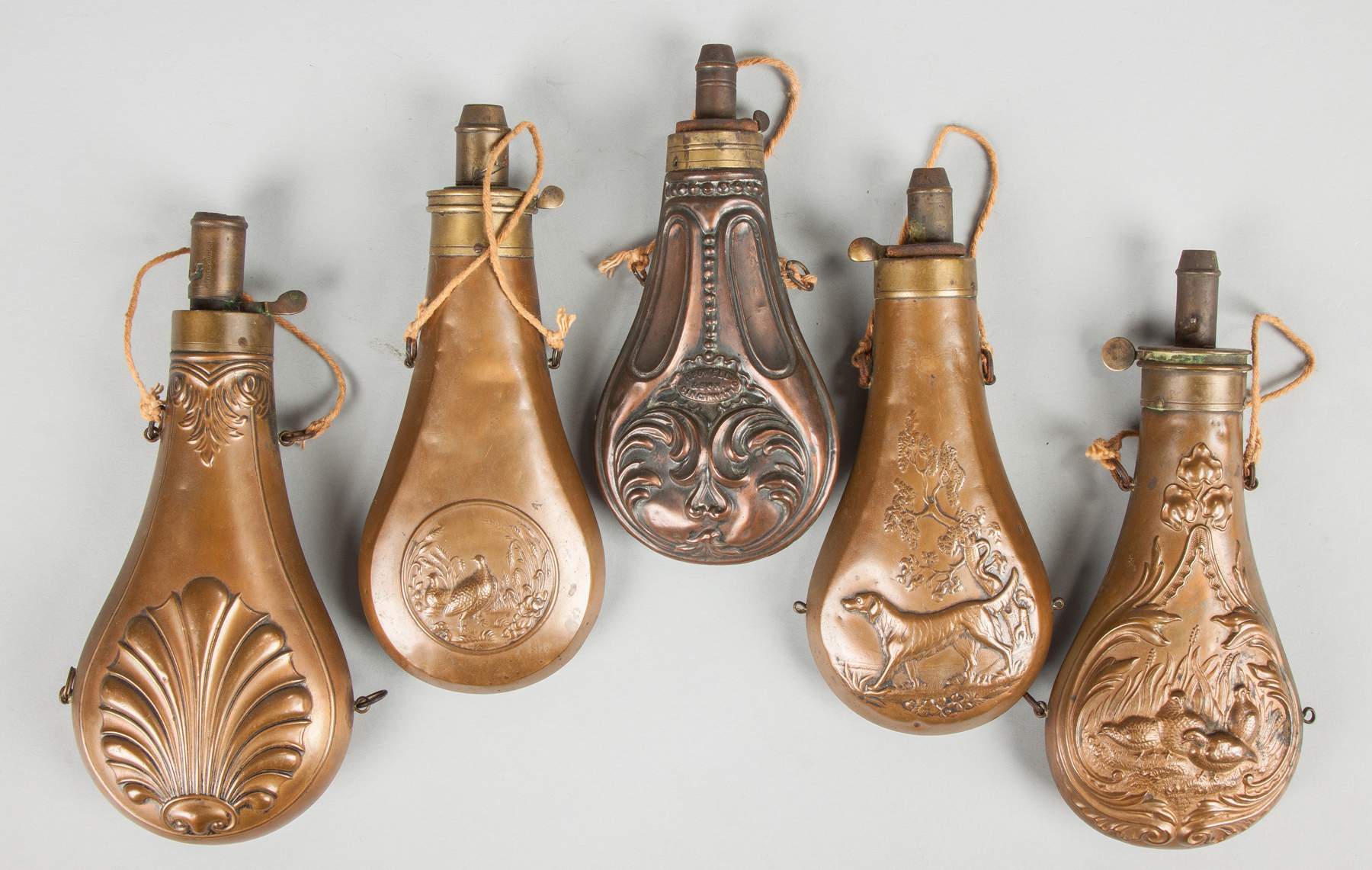 Group of Brass Embossed Powder Flasks | Cottone Auctions